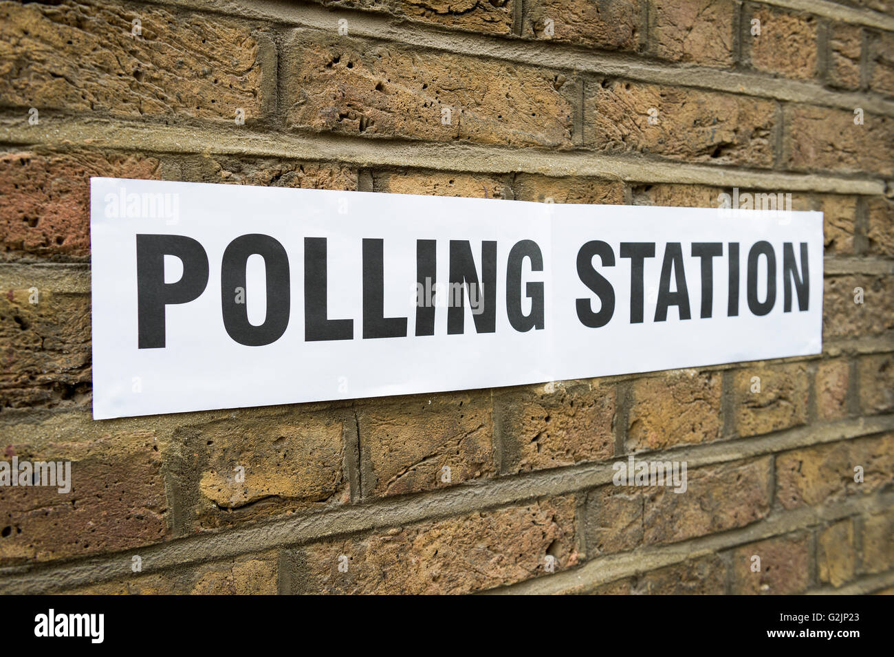 British election polling station sign hanging on classic yellow brick ...