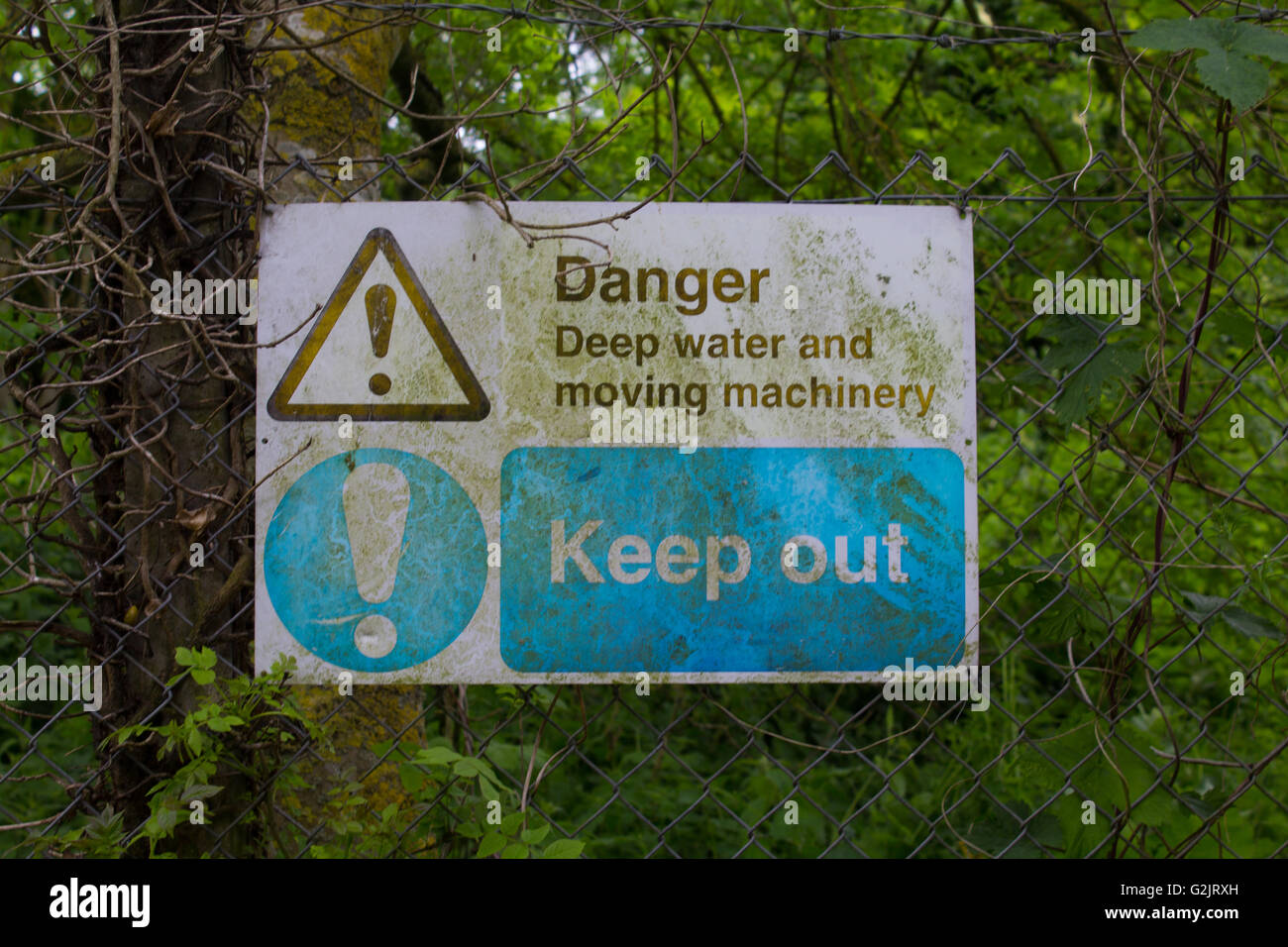 Sign affixed to wire fence reads Danger, Deep water and moving ...