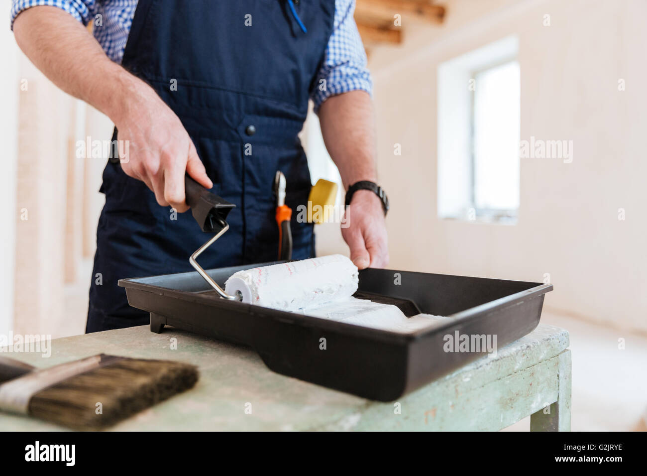 Cropped-image of a builder using paint roller in his work indoors Stock ...
