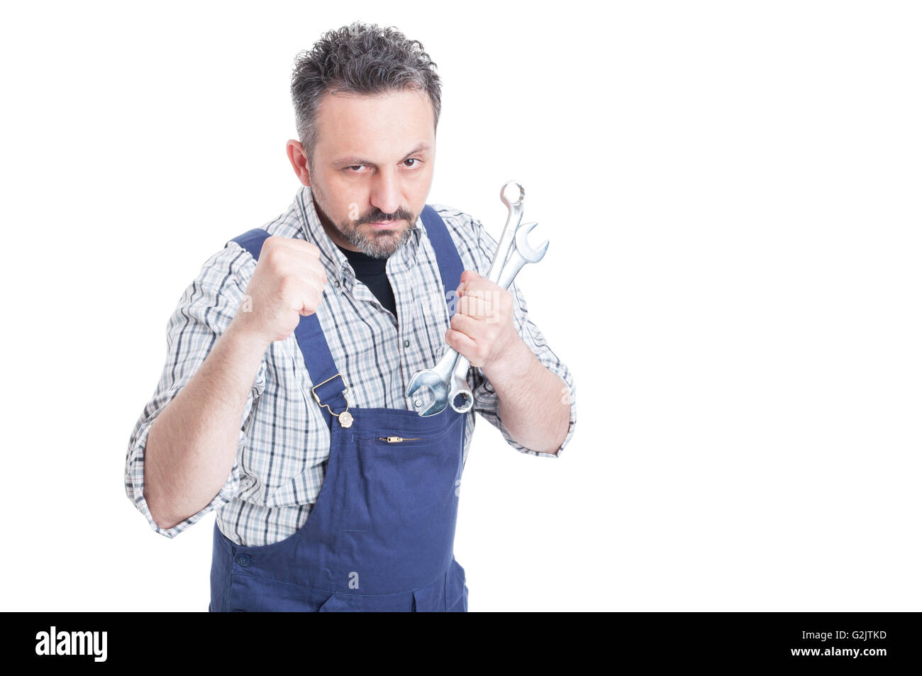 Angry young mechanic being ready for a fight showing his fists isolated ...