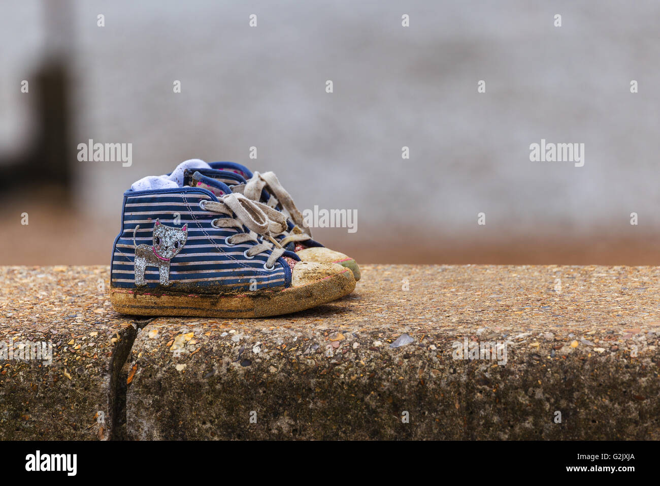 Pair of Scruffy Childrens Shoes Resting on Sea Wall Stock Photo - Alamy