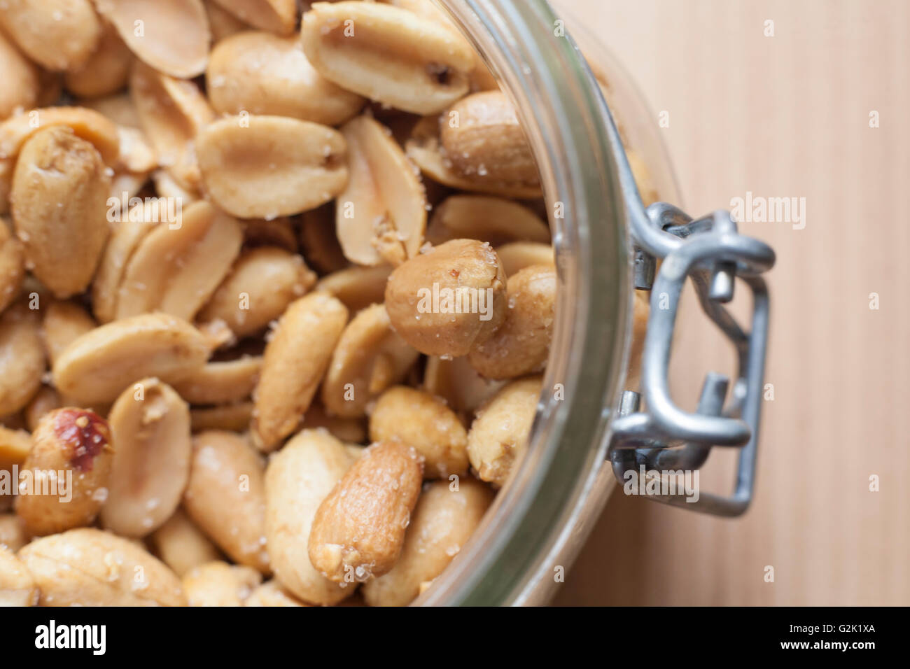 Open canning jar with fried salty peanuts. Selective focus. High angle ...