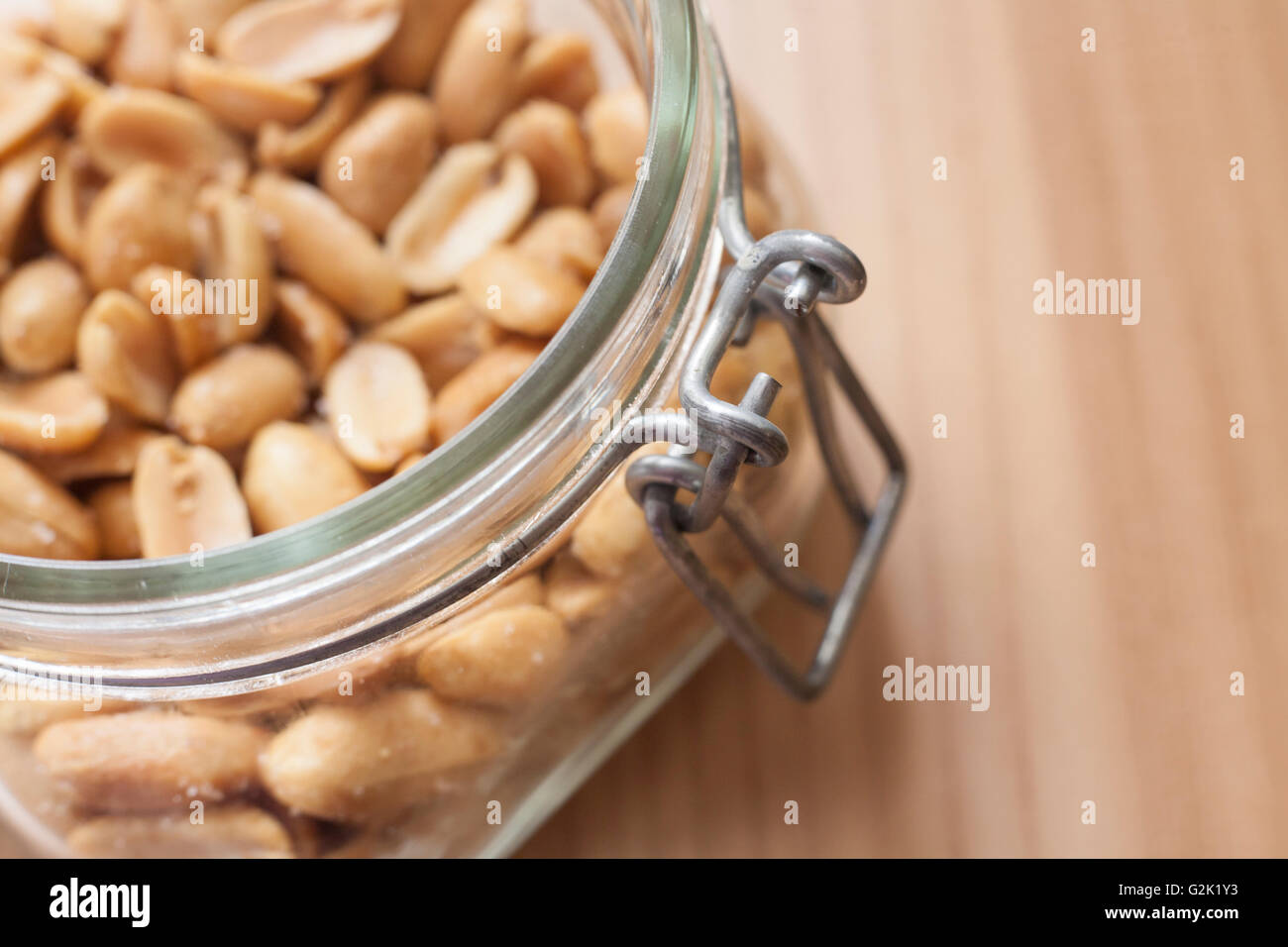 Open canning jar with fried salty peanuts. Selective focus. High angle ...