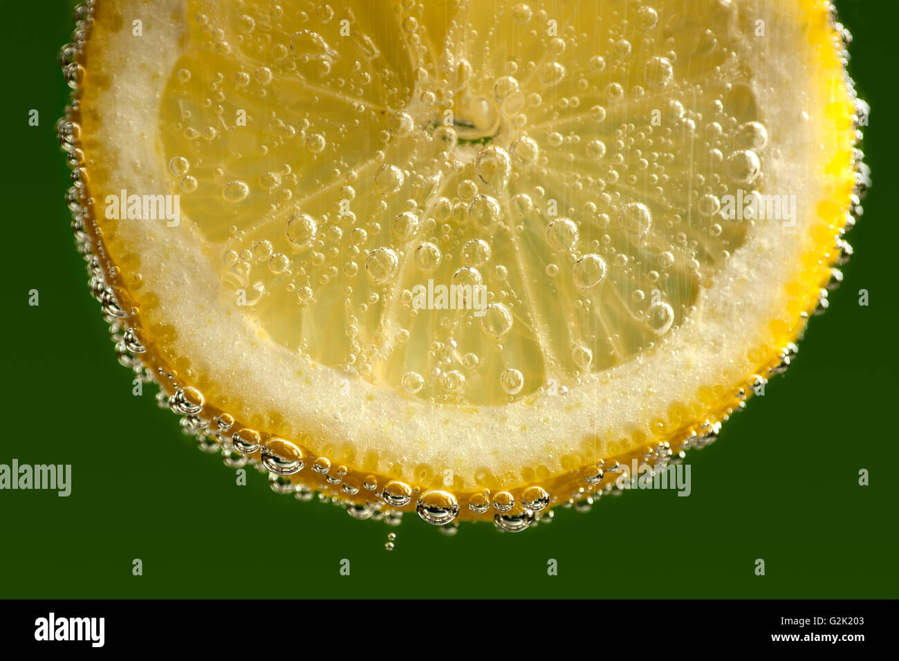 Lemon slice in bubble drink on green background Stock Photo - Alamy