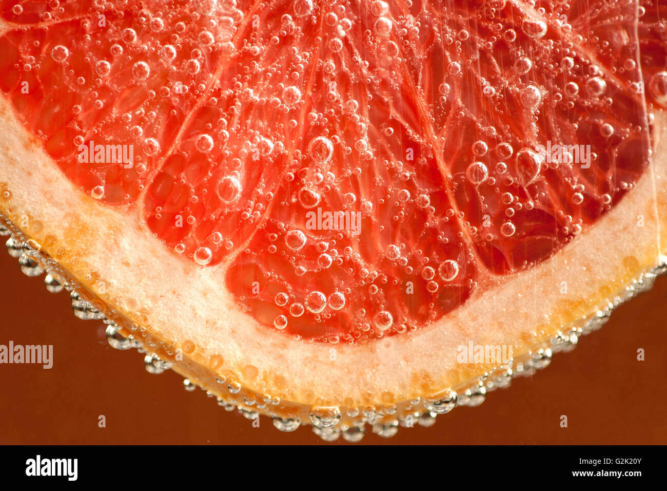 Grapefruit in fizzy bubbles on orange background Stock Photo - Alamy