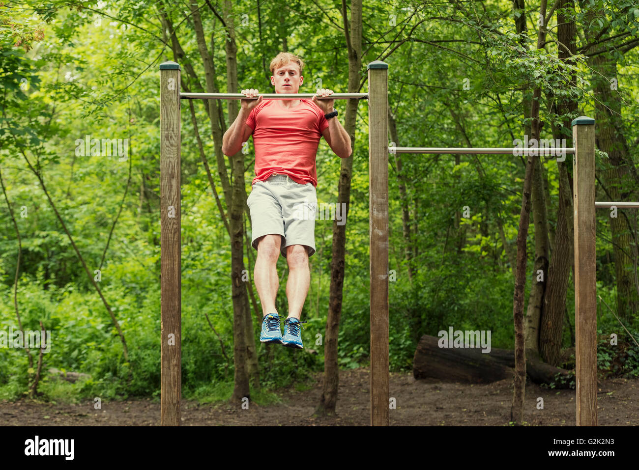 Male athlete doing muscle-up on horizontal bar Stock Photo - Alamy