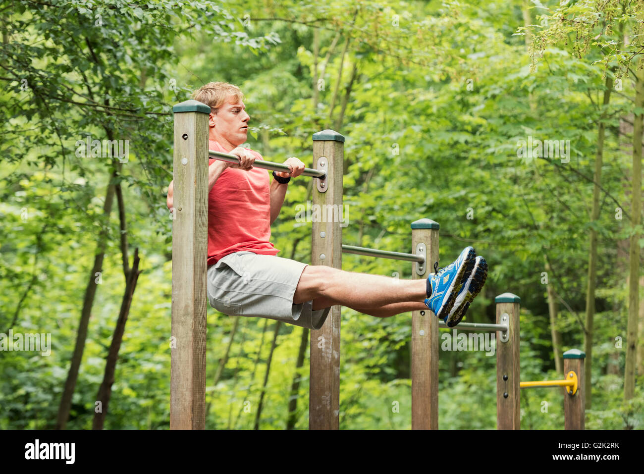 Male athlete doing muscle-up on horizontal bar Stock Photo - Alamy