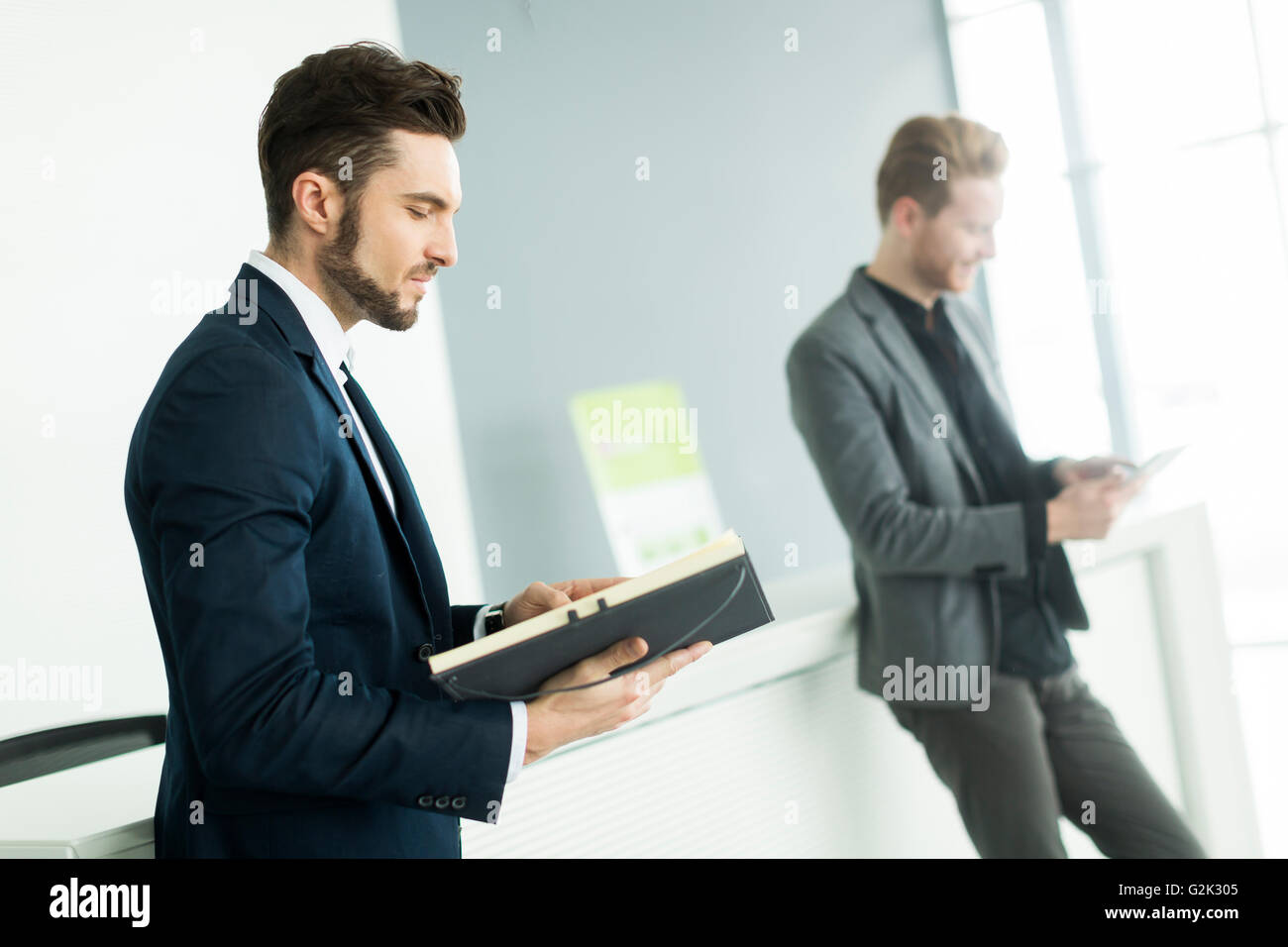 Two young men with tablet and file in the modern office Stock Photo - Alamy