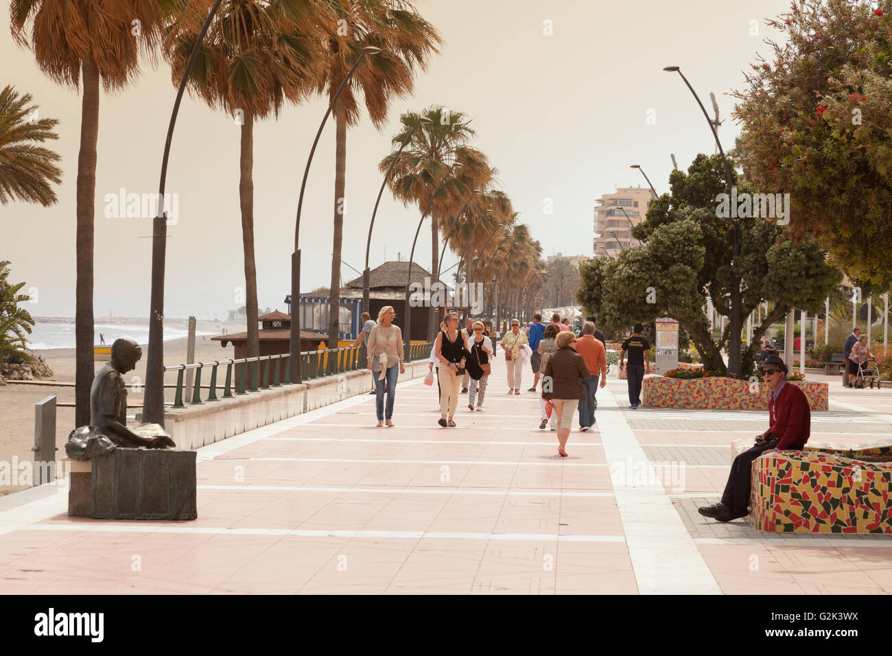 People walking past the statue of "The Tourist", the Promenade ...
