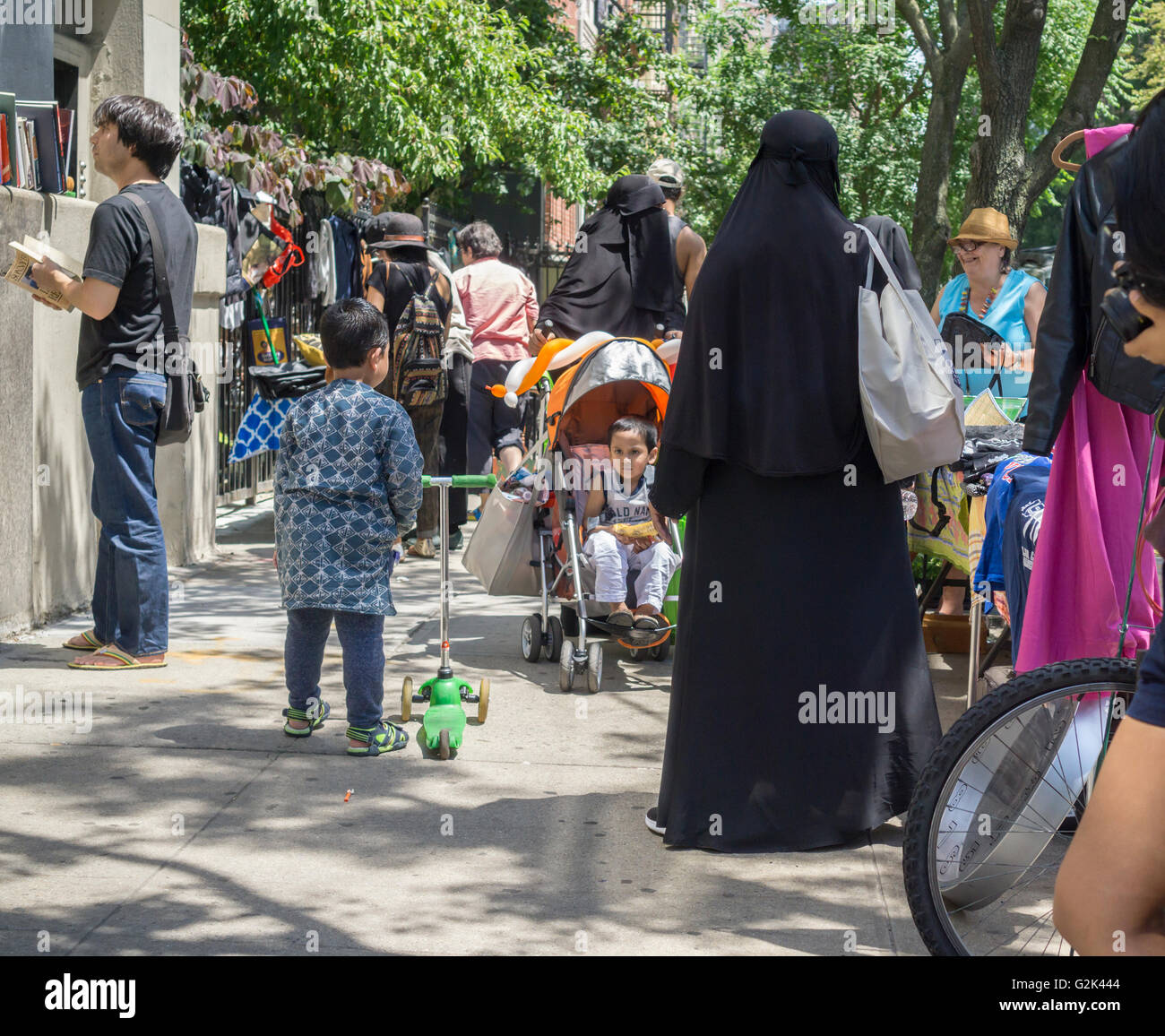 Islamic women in full burqas shop at a stoop sale the East Village ...