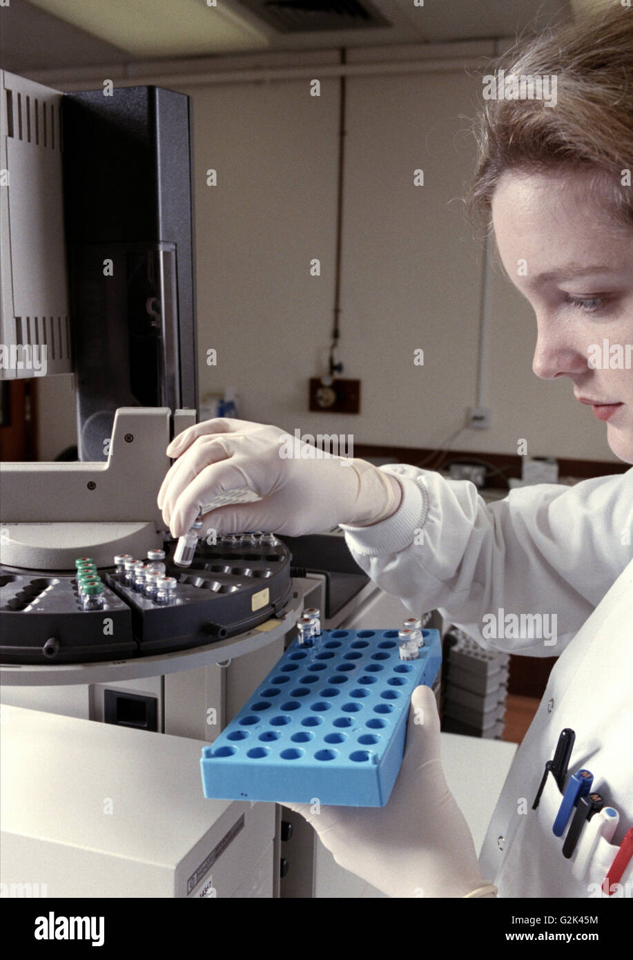 Technician loads urine samples into machine for drug testing Stock ...