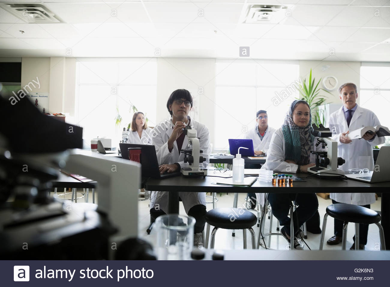 Students looking into microscopes hi-res stock photography and images ...
