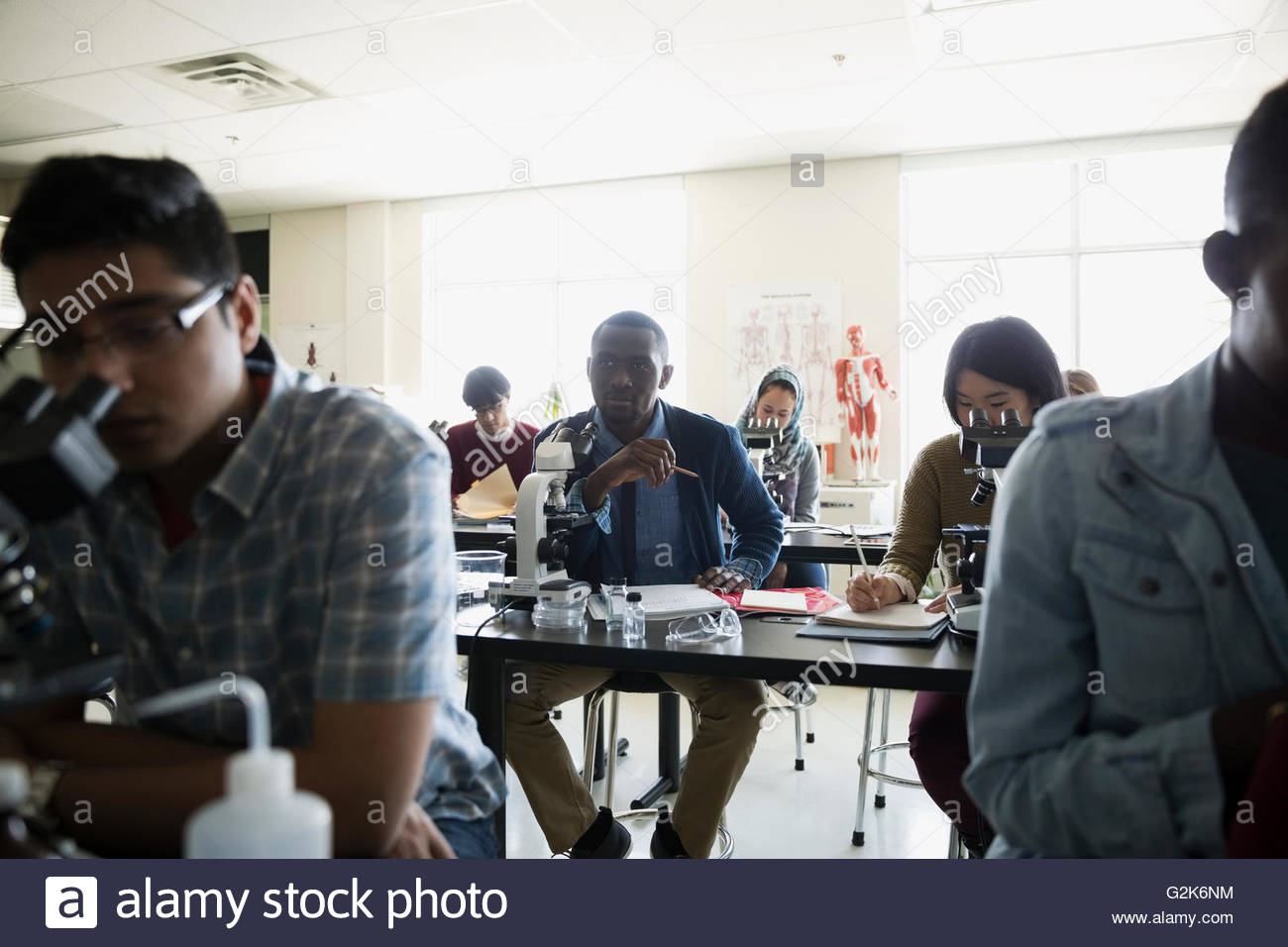 College students using microscope in science laboratory Stock Photo - Alamy
