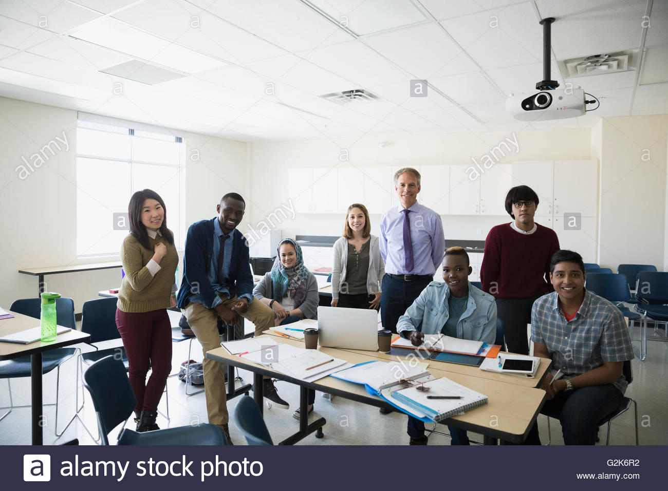 Portrait smiling professor and college students in classroom Stock ...