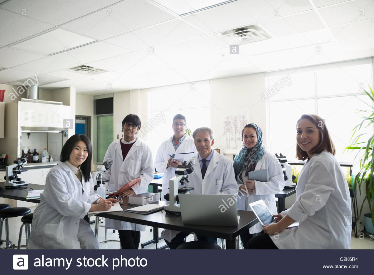 Portrait smiling professor and college students in science laboratory ...