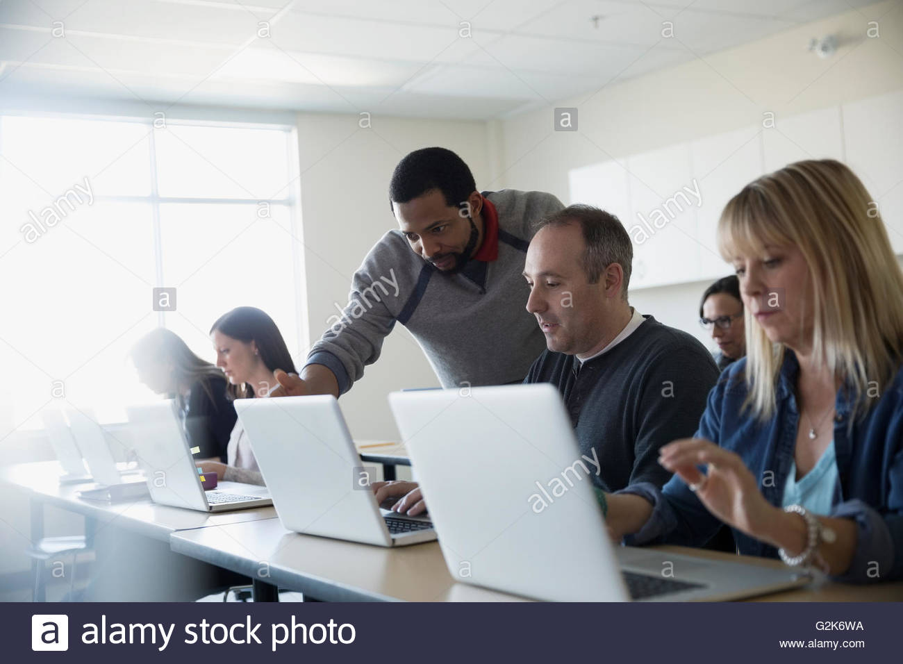 Adult education students using laptops in classroom Stock Photo - Alamy