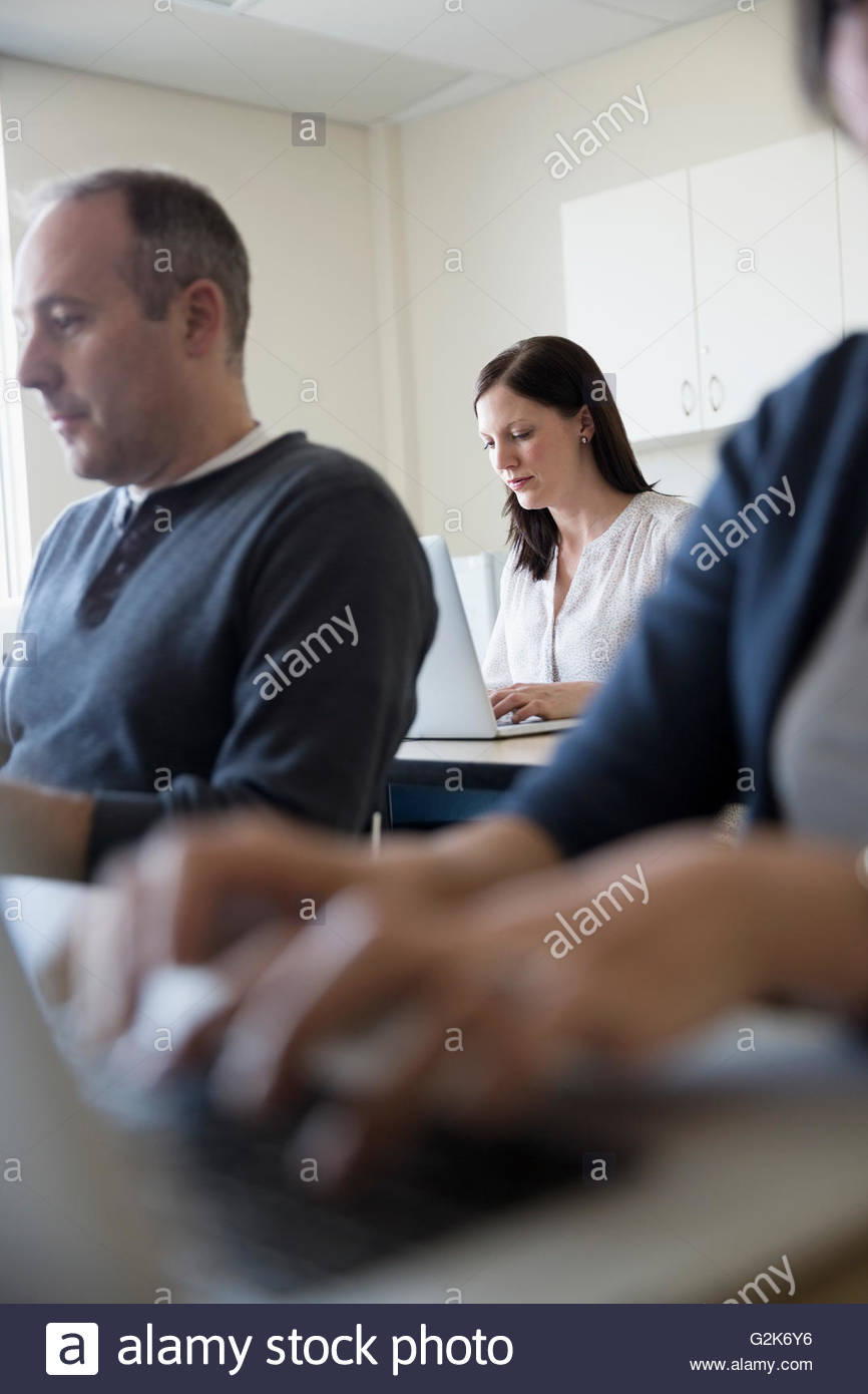 Adult education students using laptops in classroom Stock Photo - Alamy