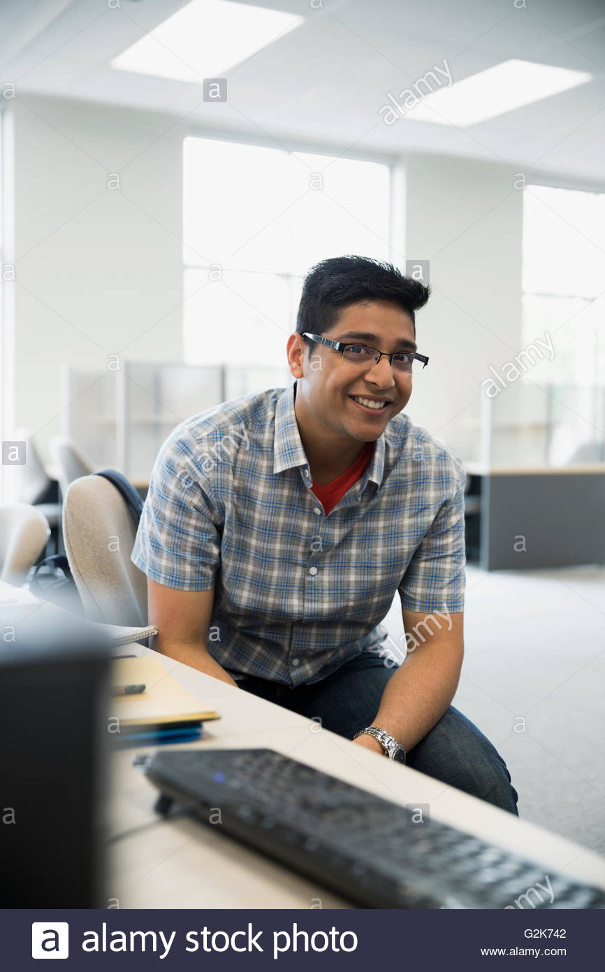Portrait smiling college student at computer in library Stock Photo - Alamy