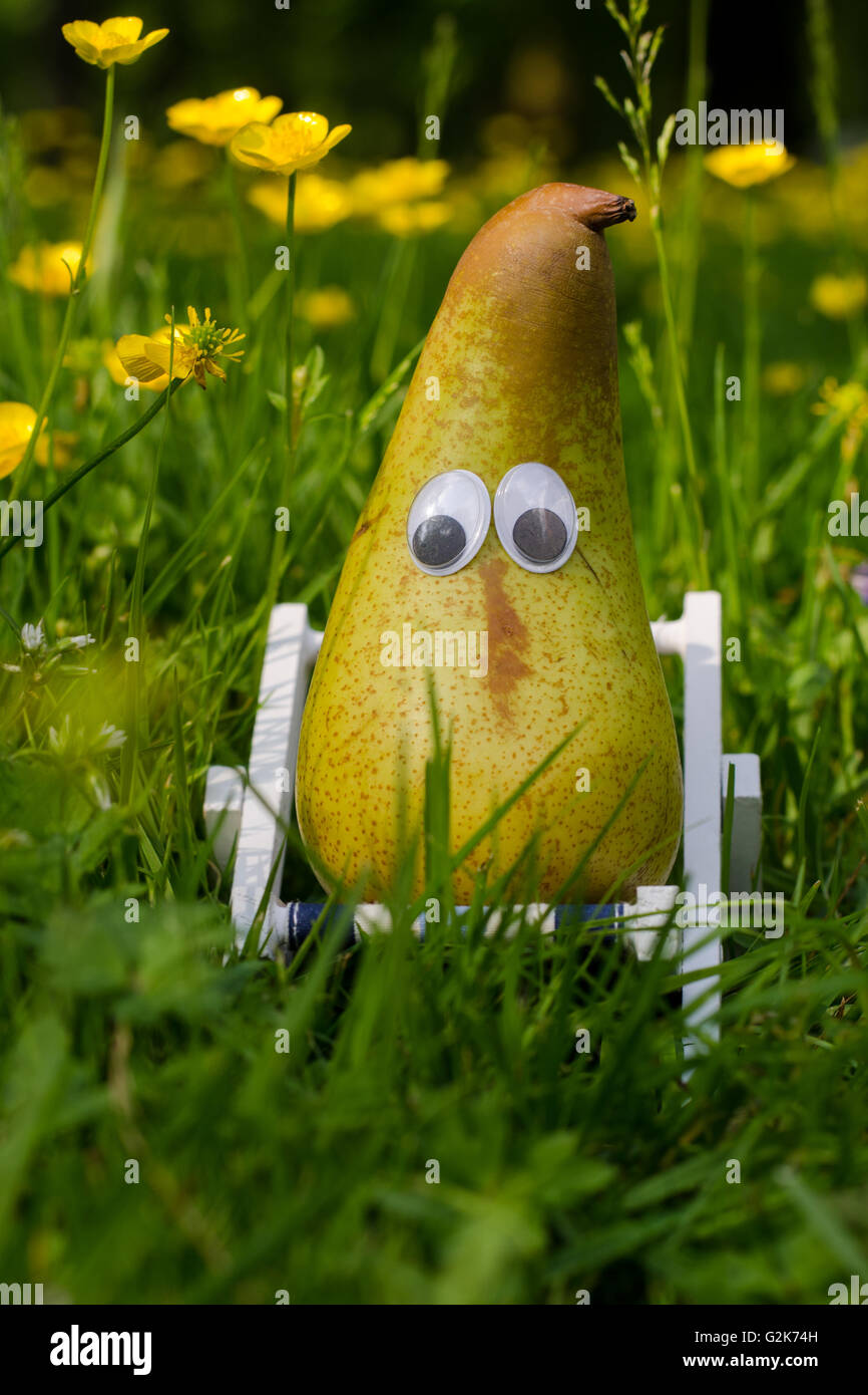 Funny pear with eyes in a summer meadow Stock Photo - Alamy
