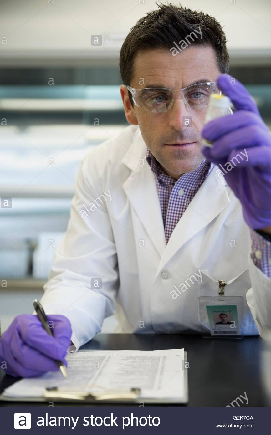 Scientist with specimen taking notes on clipboard in laboratory Stock ...