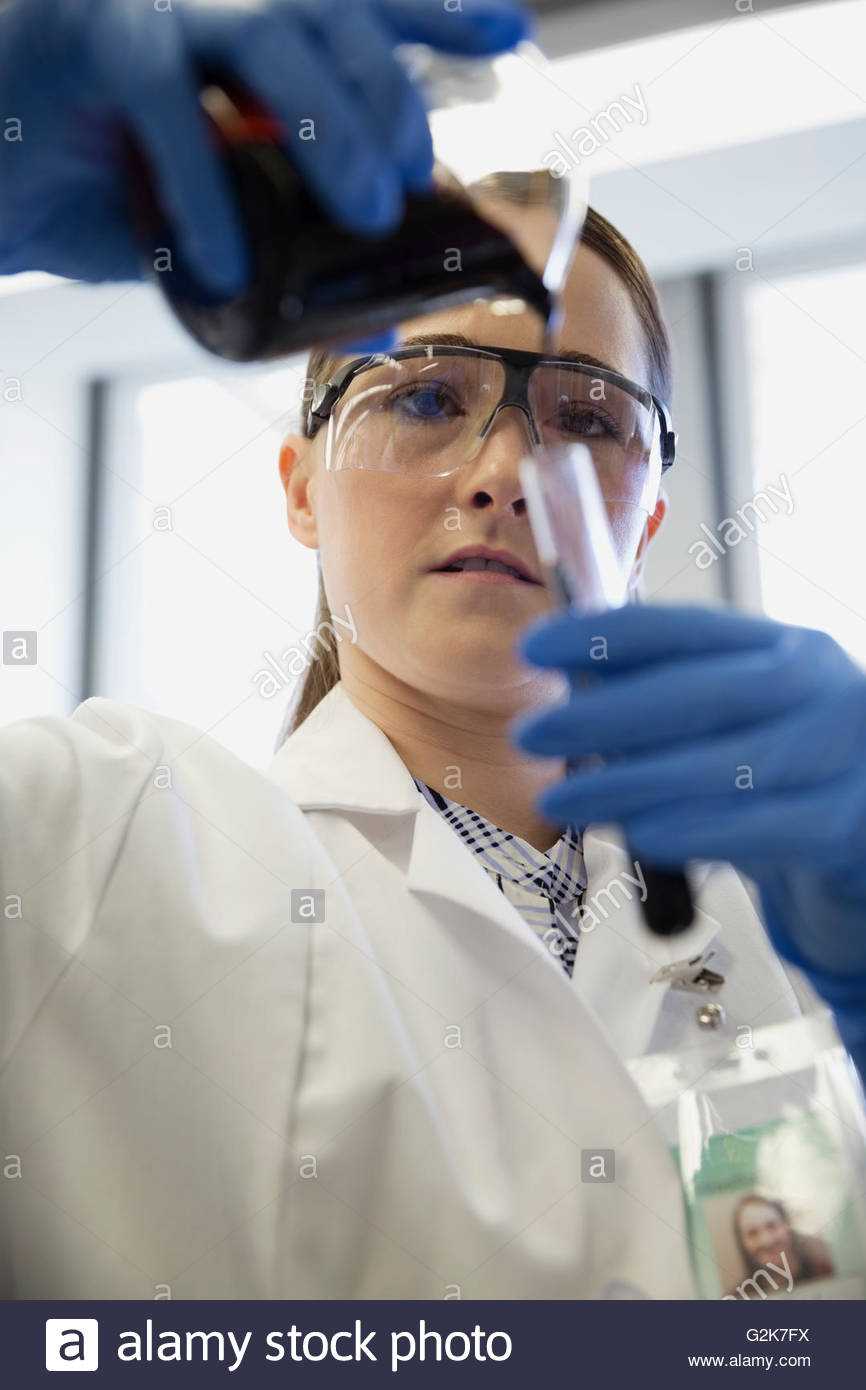 Scientist pouring liquid into beaker hi-res stock photography and ...