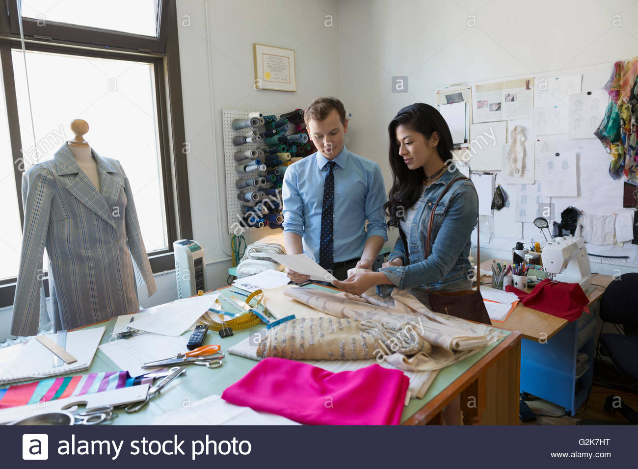 Dressmaker and customer meeting at workbench Stock Photo - Alamy