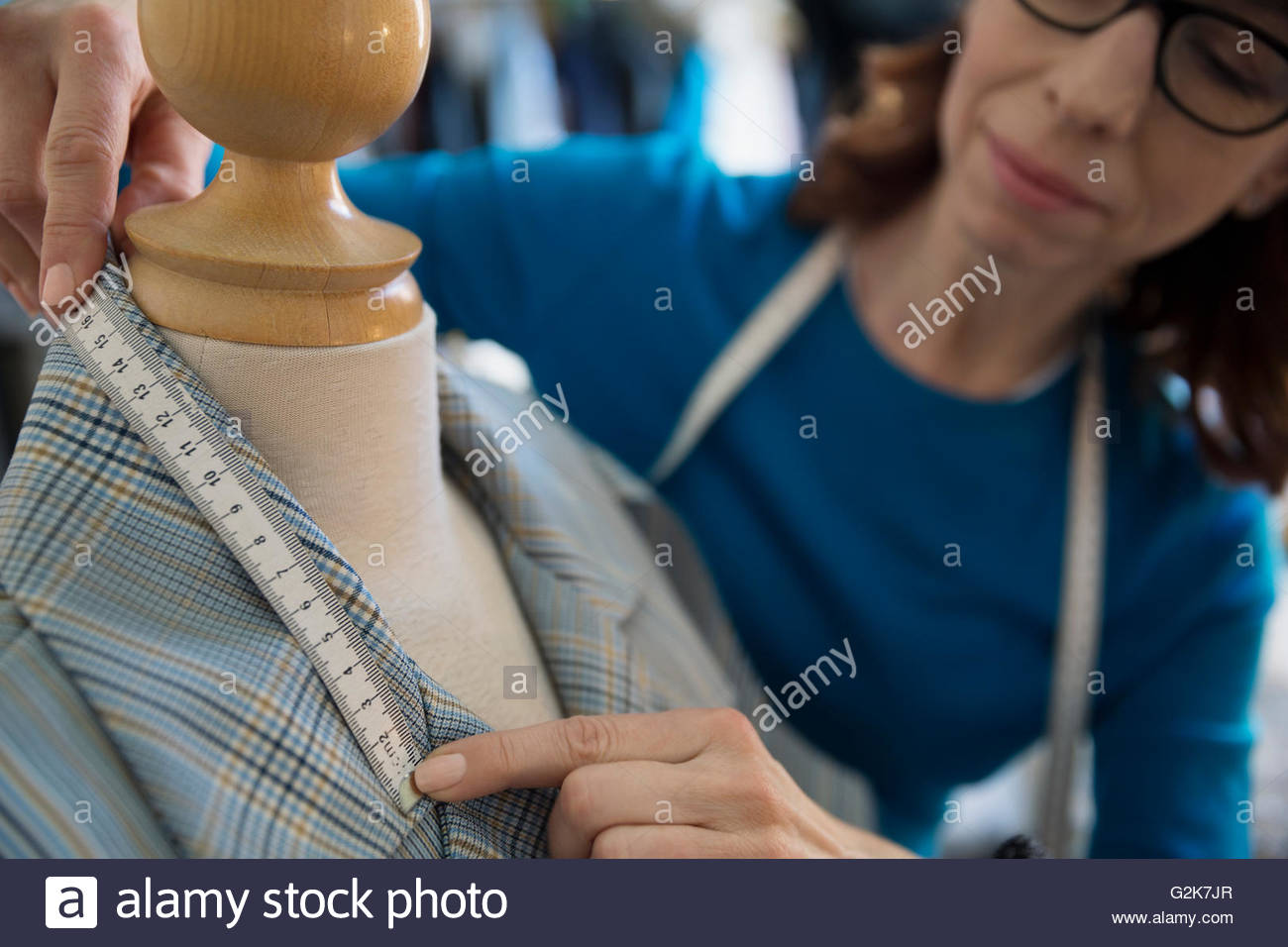 Dressmaker measuring suit on dressmakers model Stock Photo - Alamy