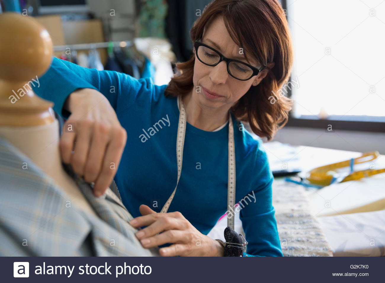 Dressmaker using tape measure on dressmakers model Stock Photo - Alamy