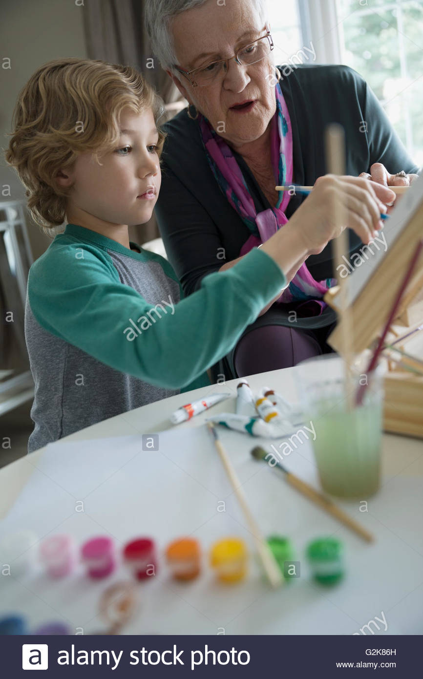 Grandmother teaching grandson how to paint Stock Photo - Alamy