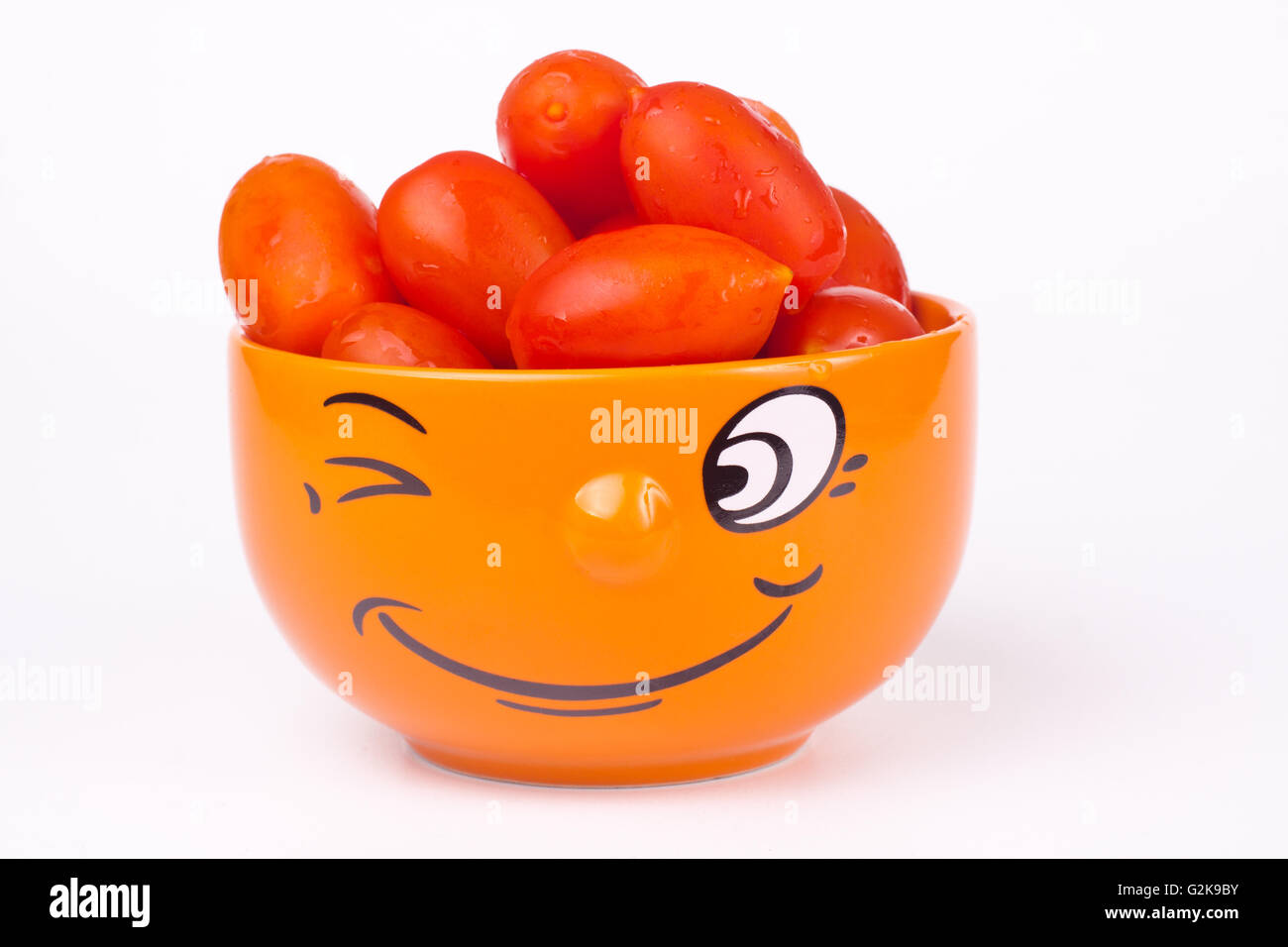 orange smiley face bowl fullwith red cherry tomato isolated on white ...