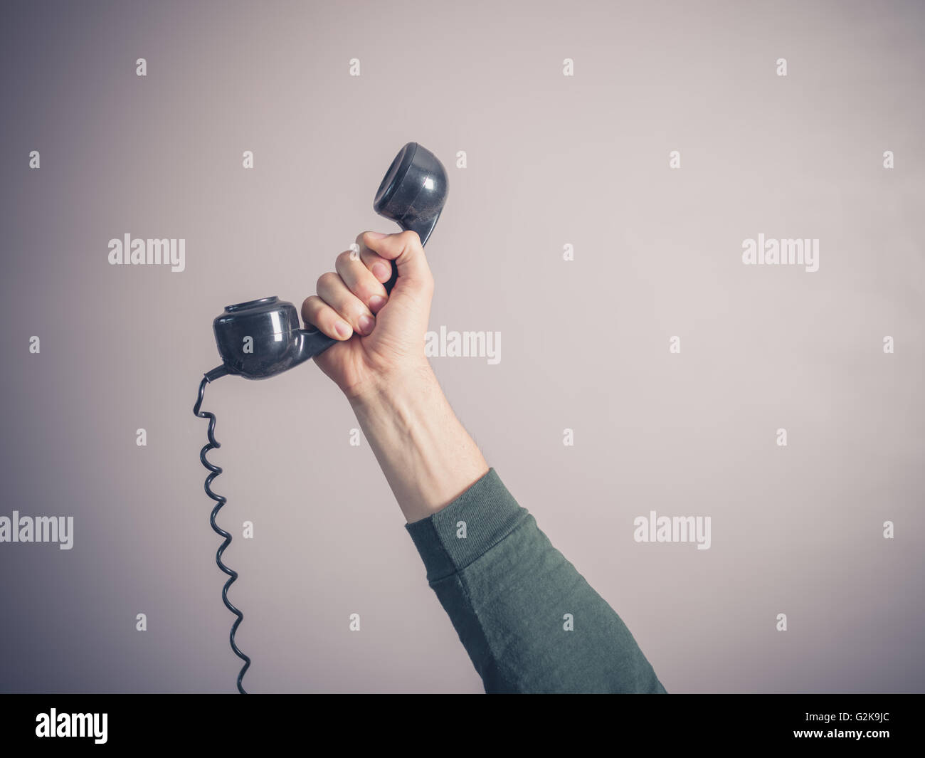 The hand of a young man is holding a vintage rotary telephone Stock ...