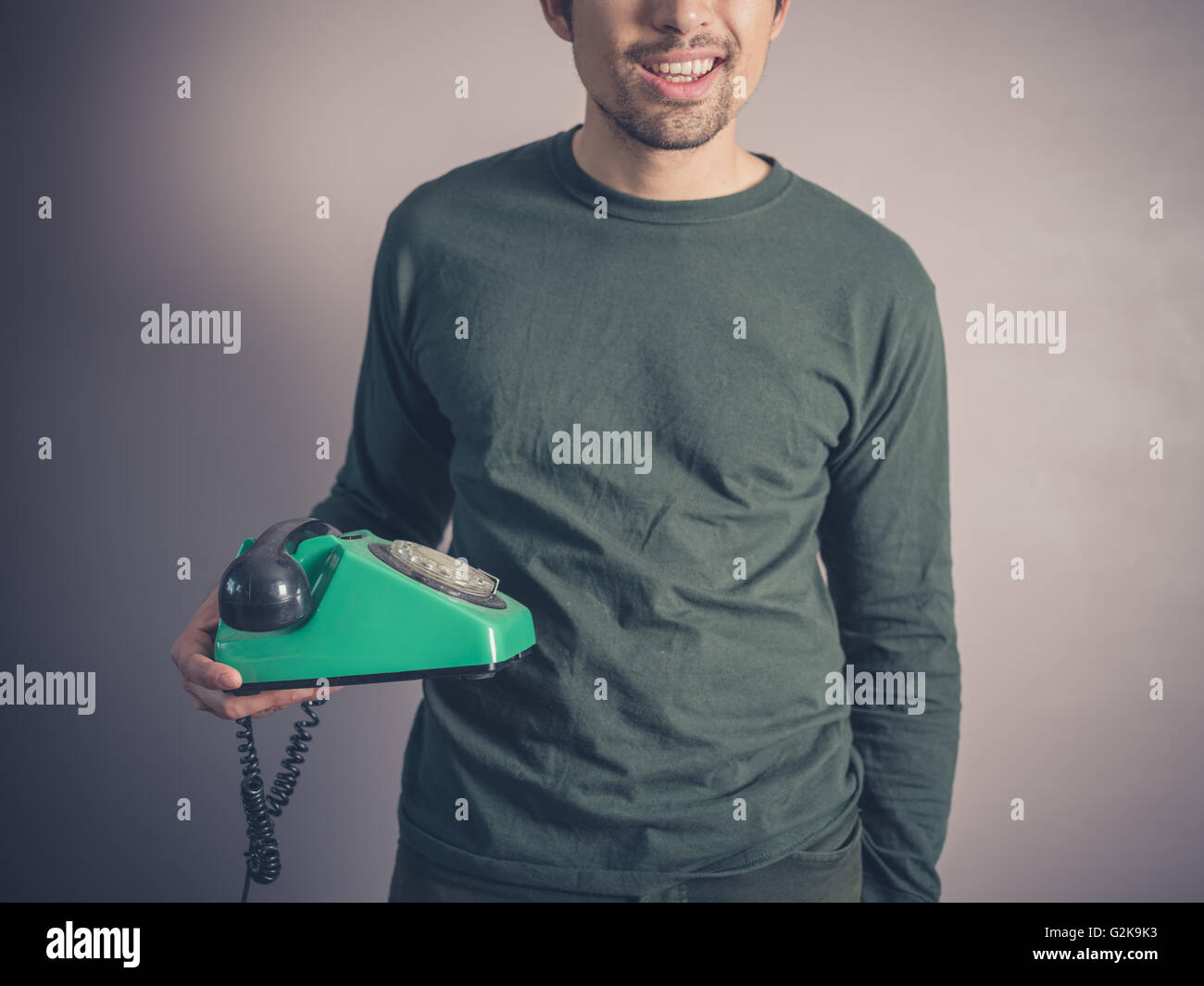 A happy young man is holding a vintage rotary phone Stock Photo - Alamy