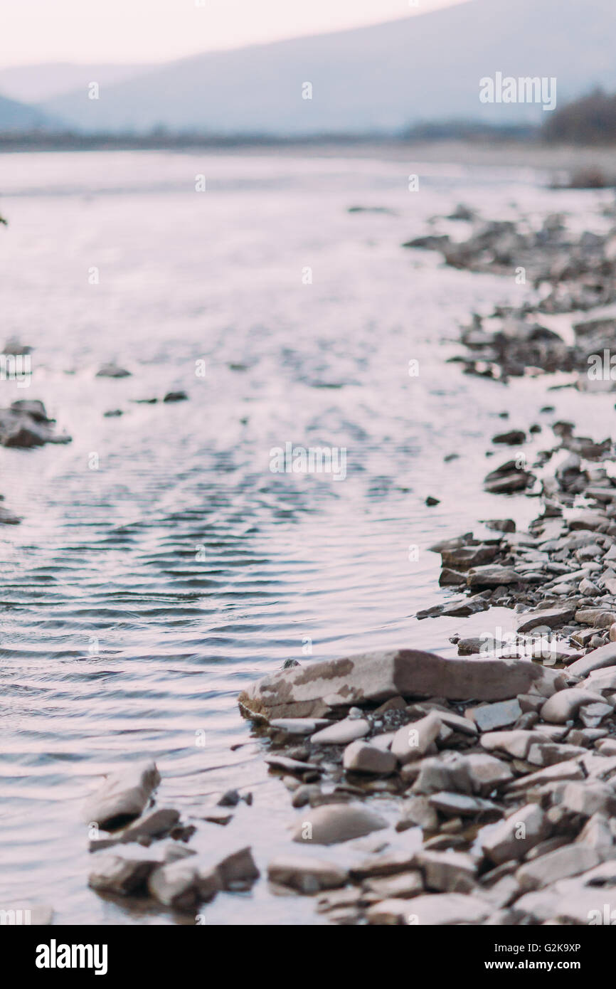 Pebble river bank with forest hills on background Stock Photo - Alamy