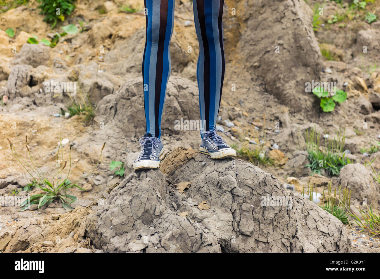 The legs of a young woman standing on a mound of dirt Stock Photo - Alamy