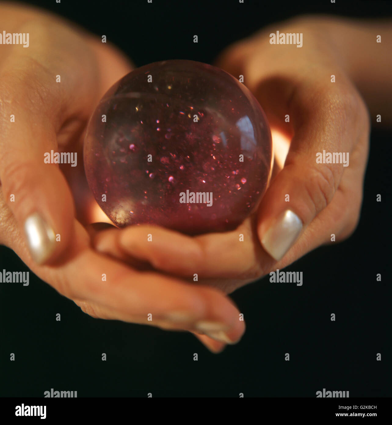 Hands Cupping a Sparkling Pink Ball Stock Photo - Alamy
