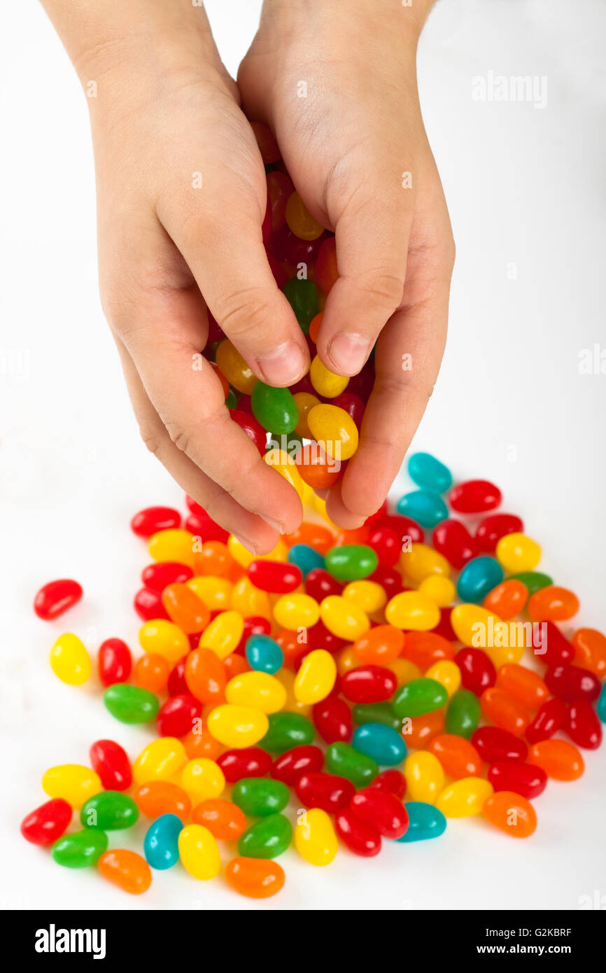 child holding colored candy with two hands on white background Stock ...