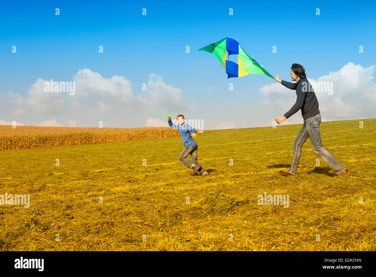 Father with son flying kite in meadow Stock Photo - Alamy