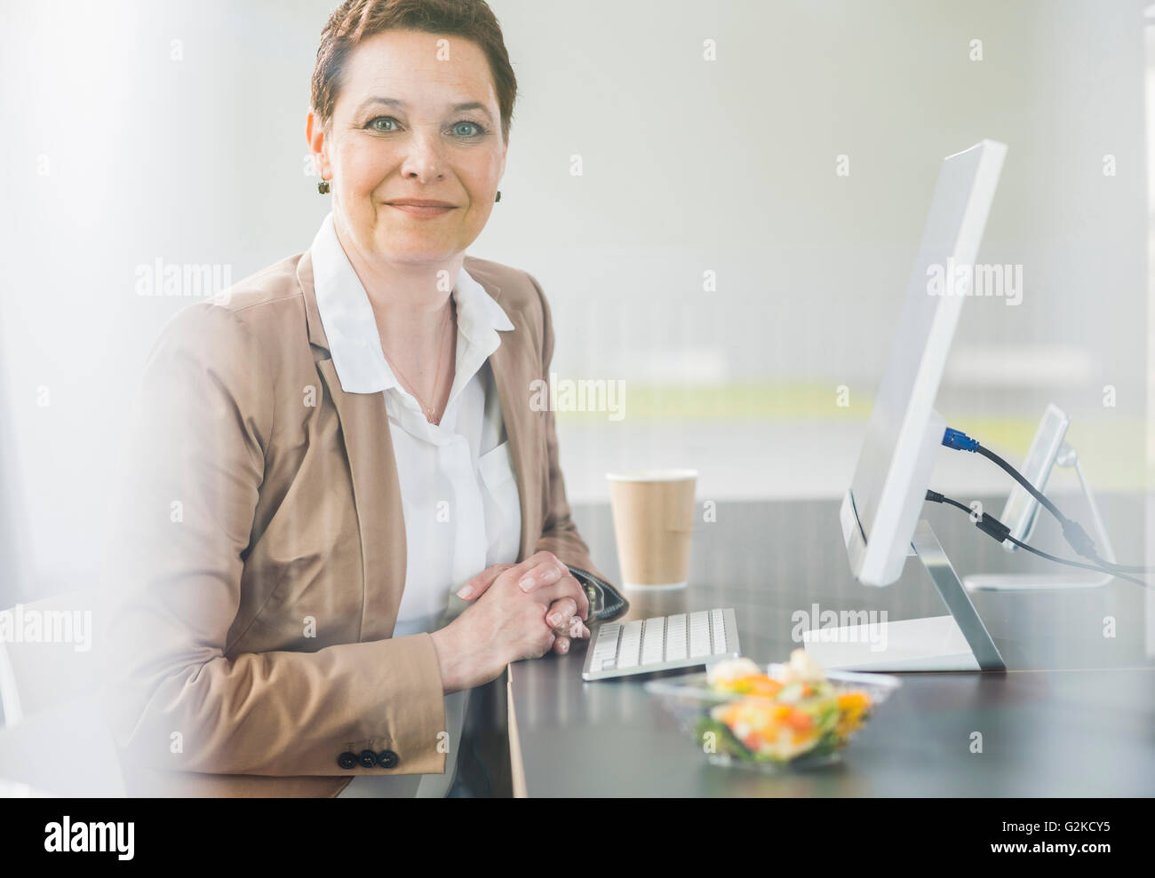 Female senior manager sitting in office, smiling Stock Photo - Alamy