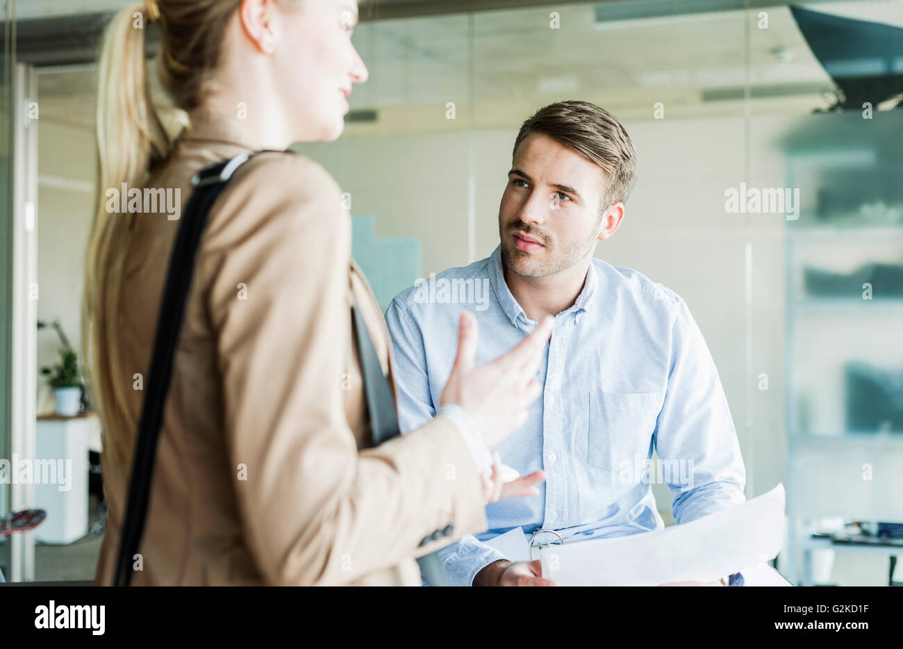 Two colleagues in office talking Stock Photo - Alamy