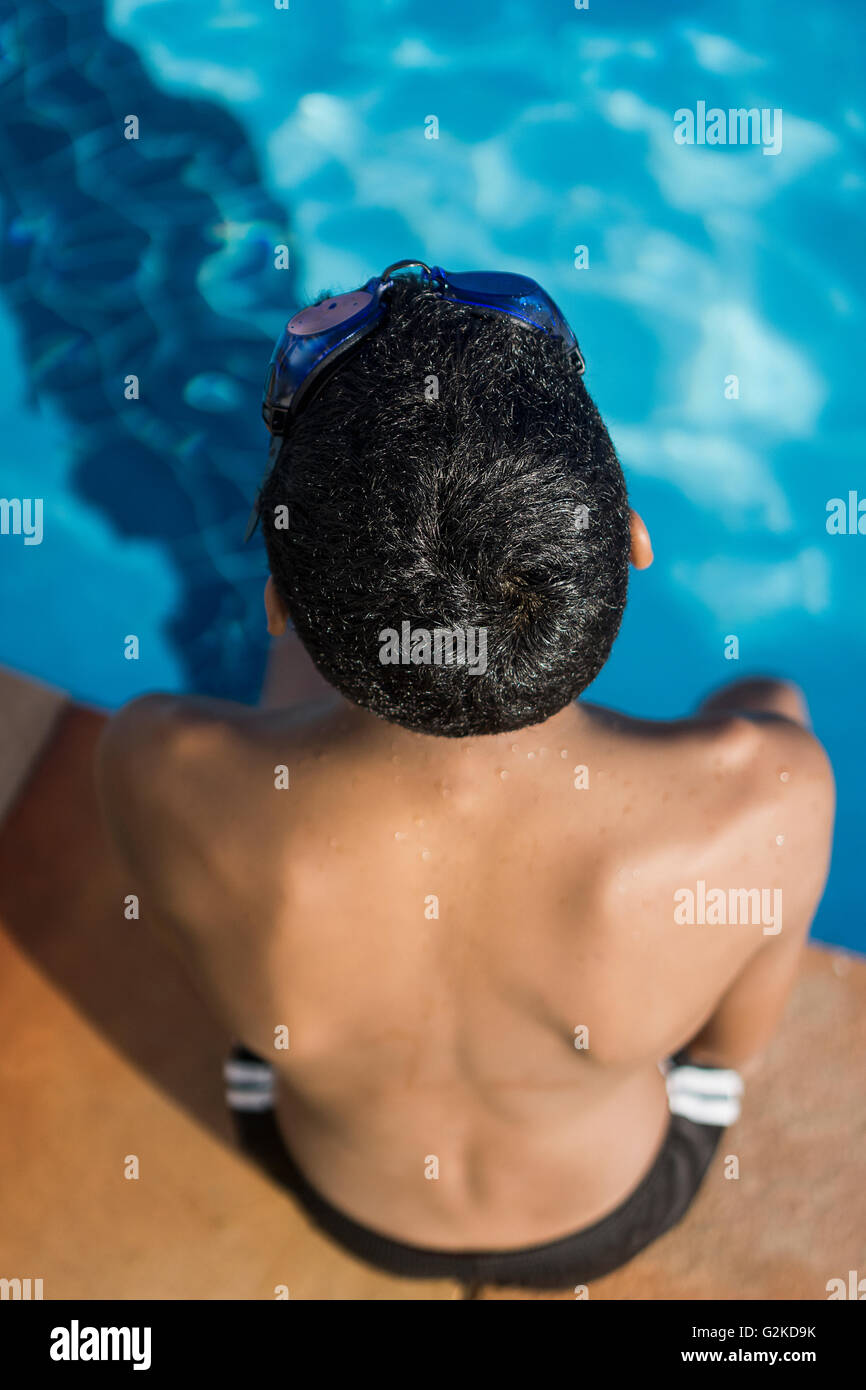 Teenage boy sitting at pool edge Stock Photo - Alamy