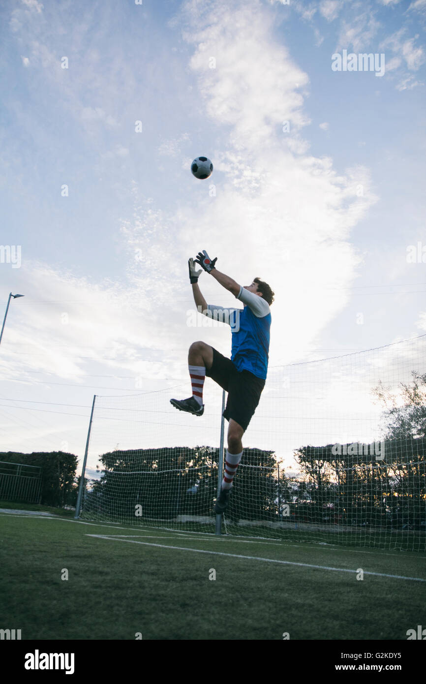 Goalkeeper trying to catch football Stock Photo - Alamy