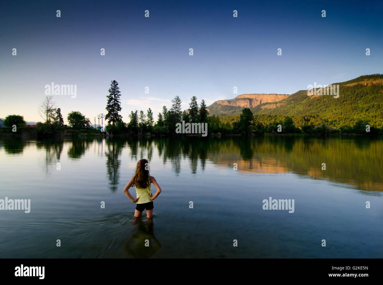 Young girl wading into Shuswap River while watching last light hit ...