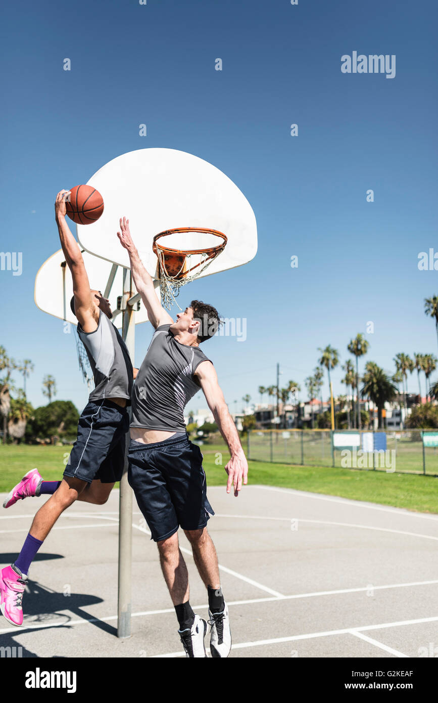 Two young men playing basketball on an outdoor court Stock Photo - Alamy