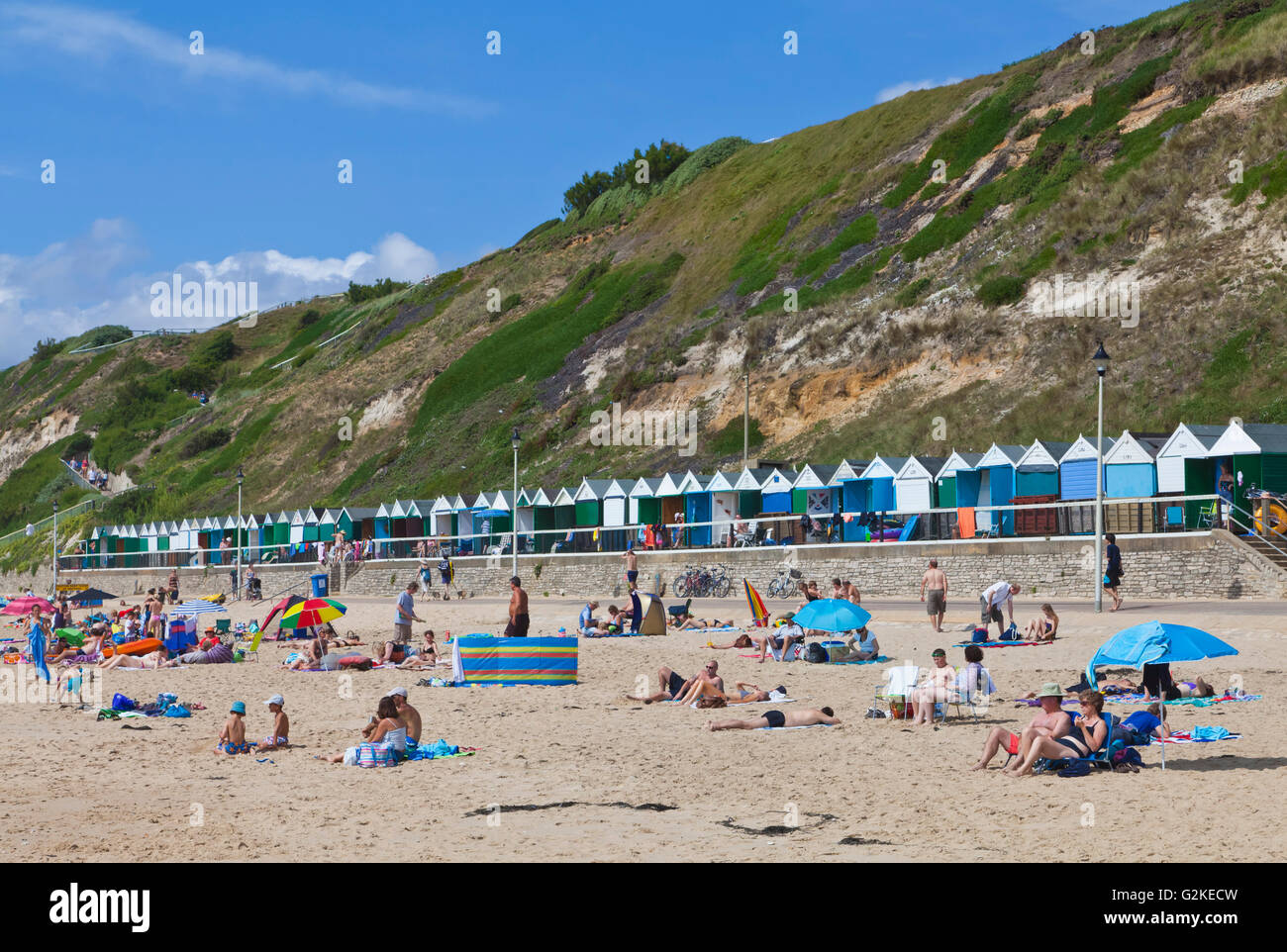 People on the beach, beach life, colourful beach huts at back ...