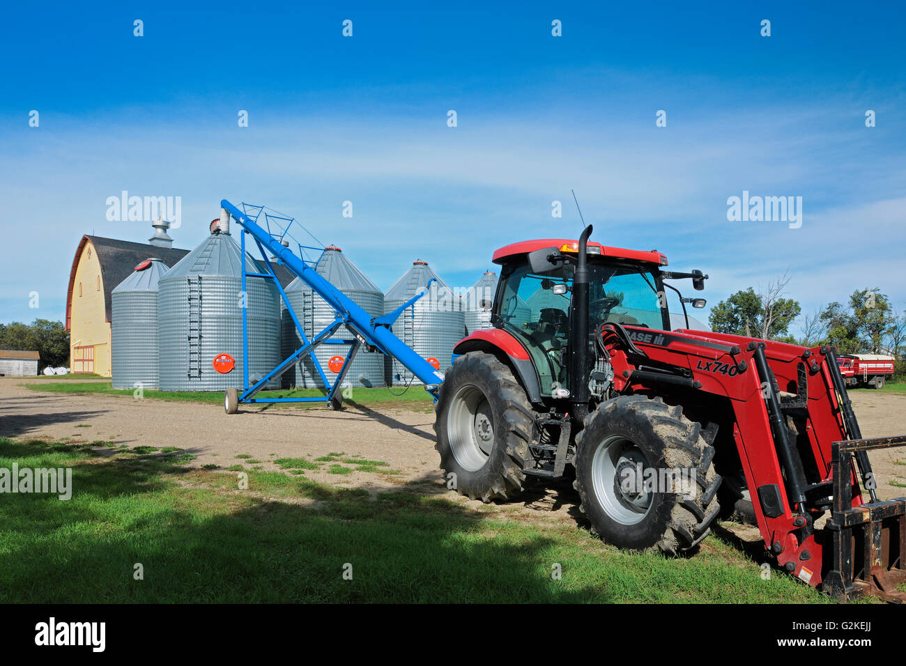 Grain bins, tractor and auger in farmyard - Property Released Yellow ...