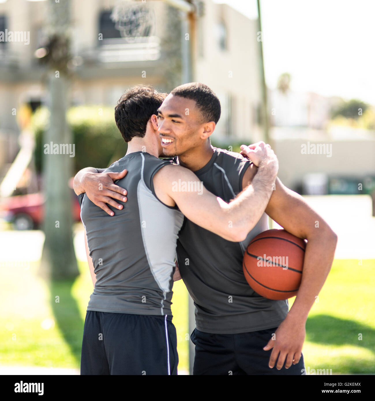 Two basketball players embracing outdoors Stock Photo - Alamy