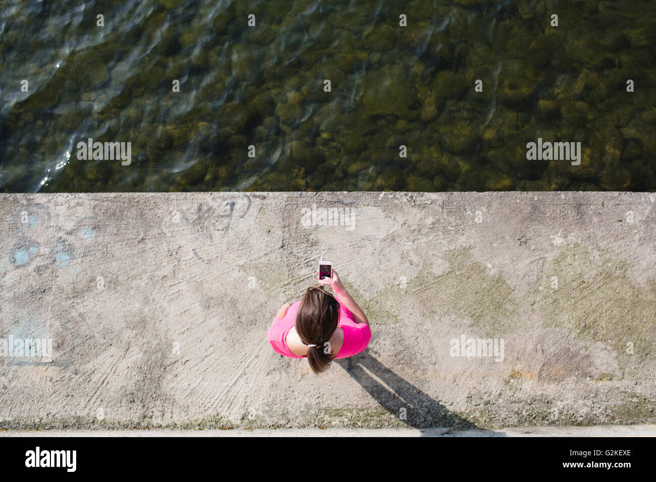 Young woman using cell phone at lakeshore Stock Photo - Alamy