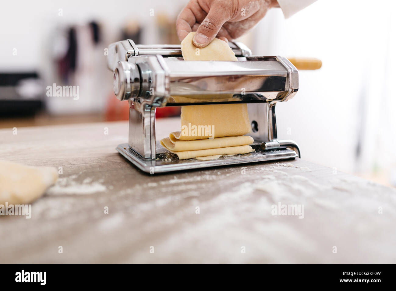 Chef rolling dough with pasta machine Stock Photo - Alamy