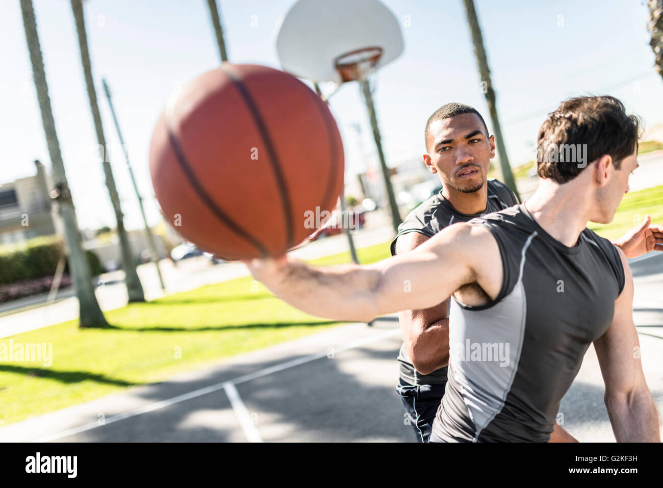 Two young men playing basketball on an outdoor court Stock Photo - Alamy