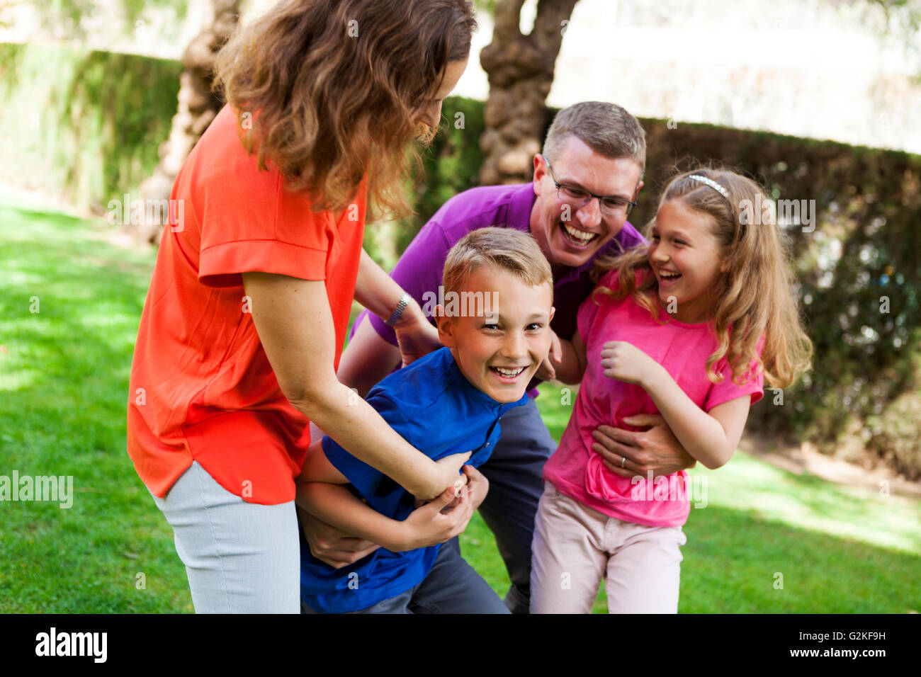 Happy family playing together in the garden Stock Photo - Alamy